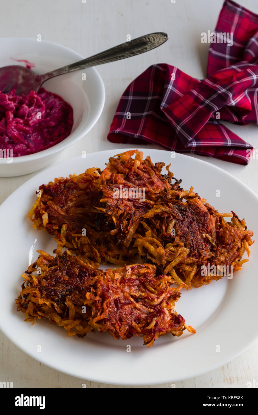 beetroot and potato rosti on white plate and table Stock Photo - Alamy