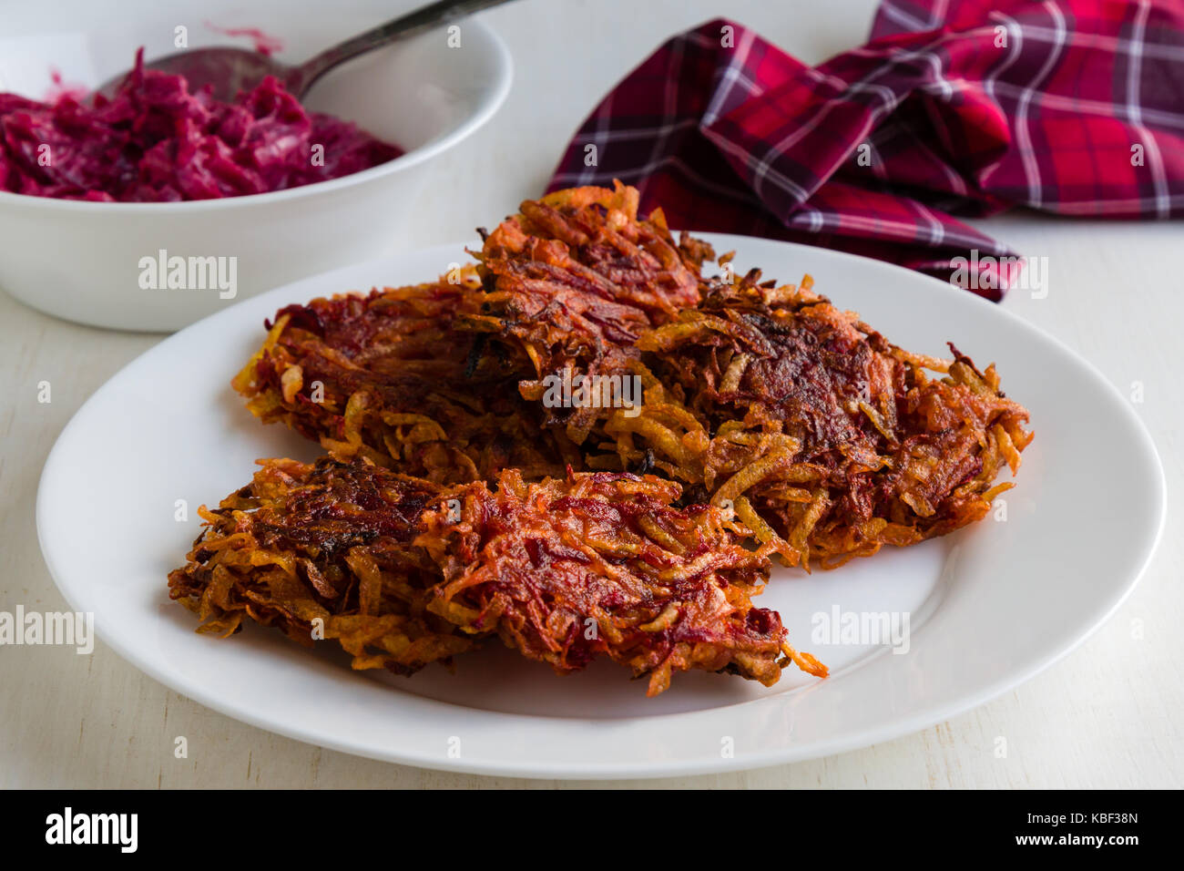 beetroot and potato rosti on white plate and table Stock Photo - Alamy