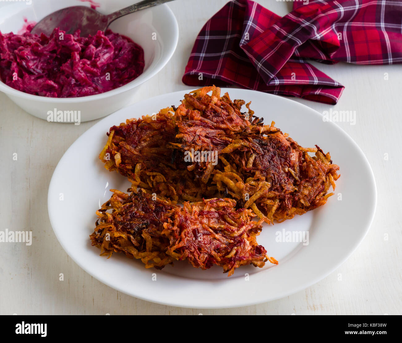 beetroot and potato rosti on white plate and table Stock Photo - Alamy