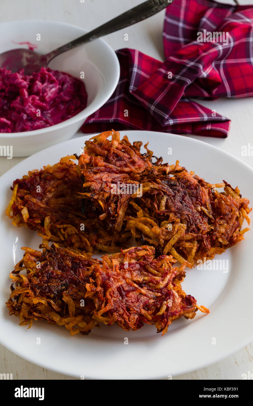 beetroot and potato rosti on white plate and table Stock Photo - Alamy