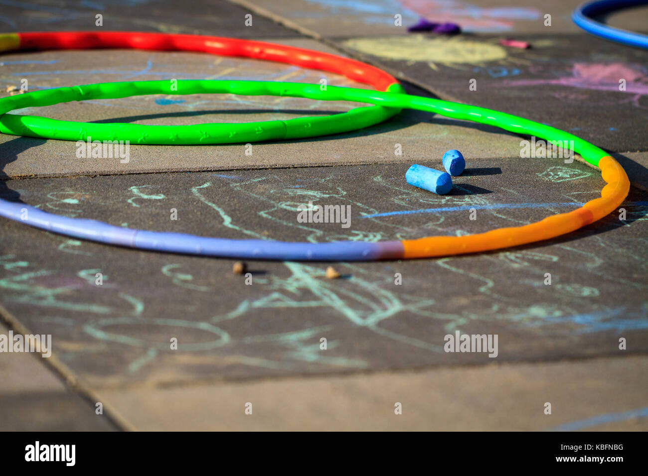 Colourful chalk and hula hoops lay on playground Stock Photo - Alamy