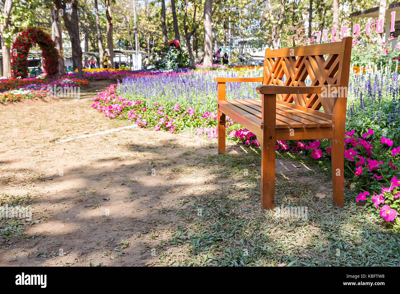 Wooden bench in the colorful flower garden Stock Photo - Alamy