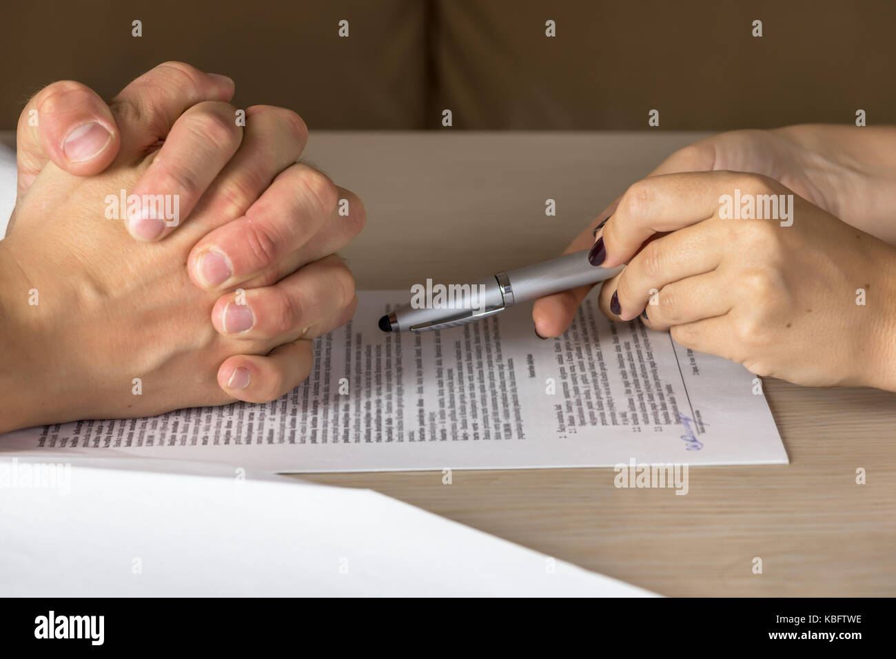 Hands of contractual parties, a woman and a man, signing a contract ...