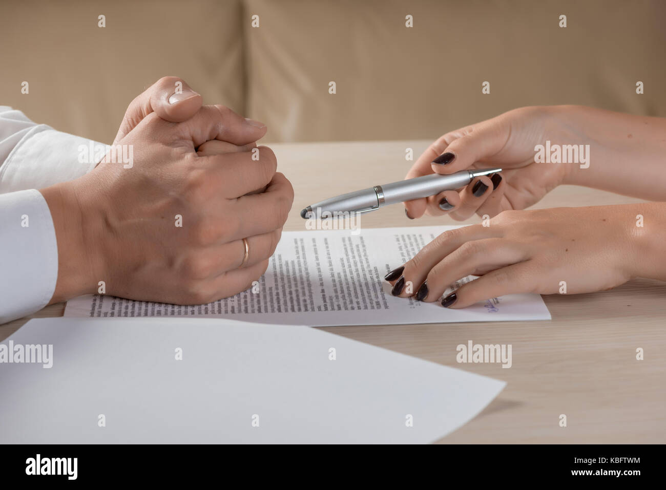 Hands of contractual parties, a woman and a man, signing a contract ...