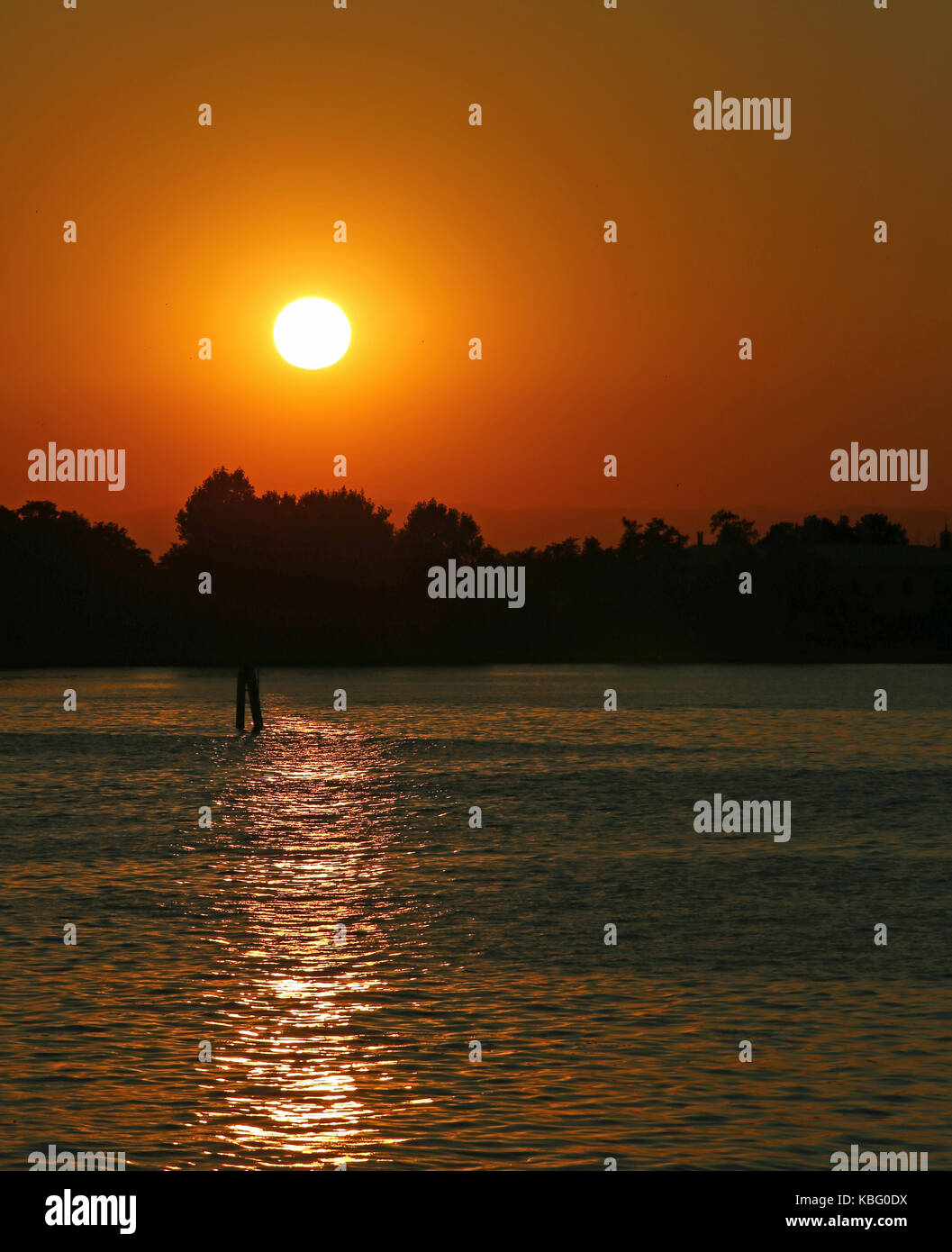 Yellow Big sun at the SUNSET with reflections on the water of venetian ...