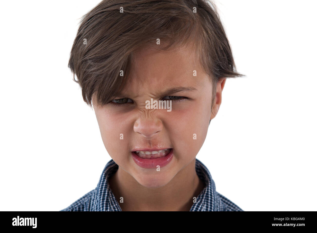 Portrait of angry boy standing against white background Stock Photo - Alamy