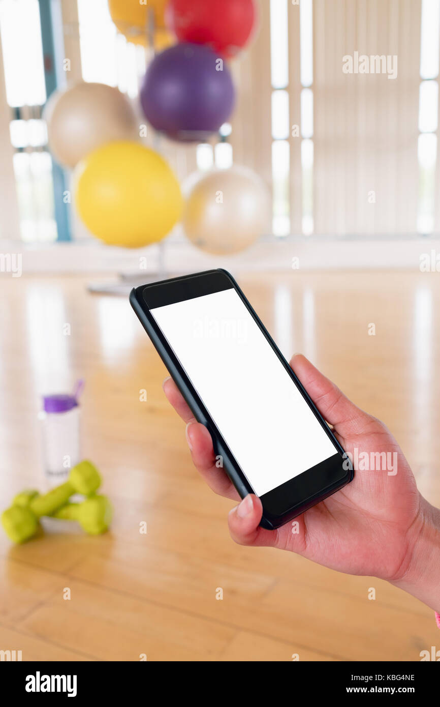 Womans hand holding mobile phone in the gym Stock Photo - Alamy