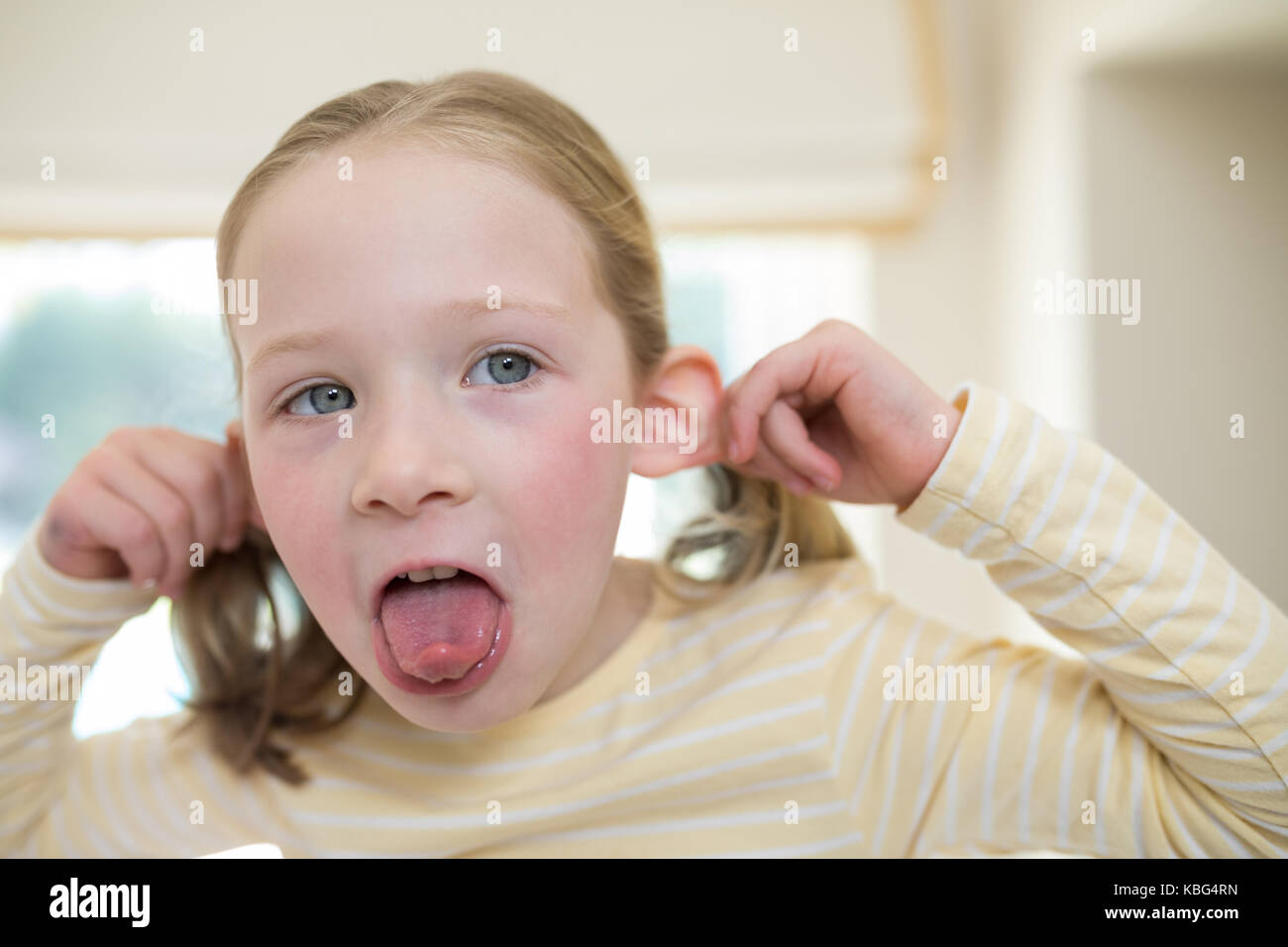 Young girl making funny faces at home Stock Photo - Alamy