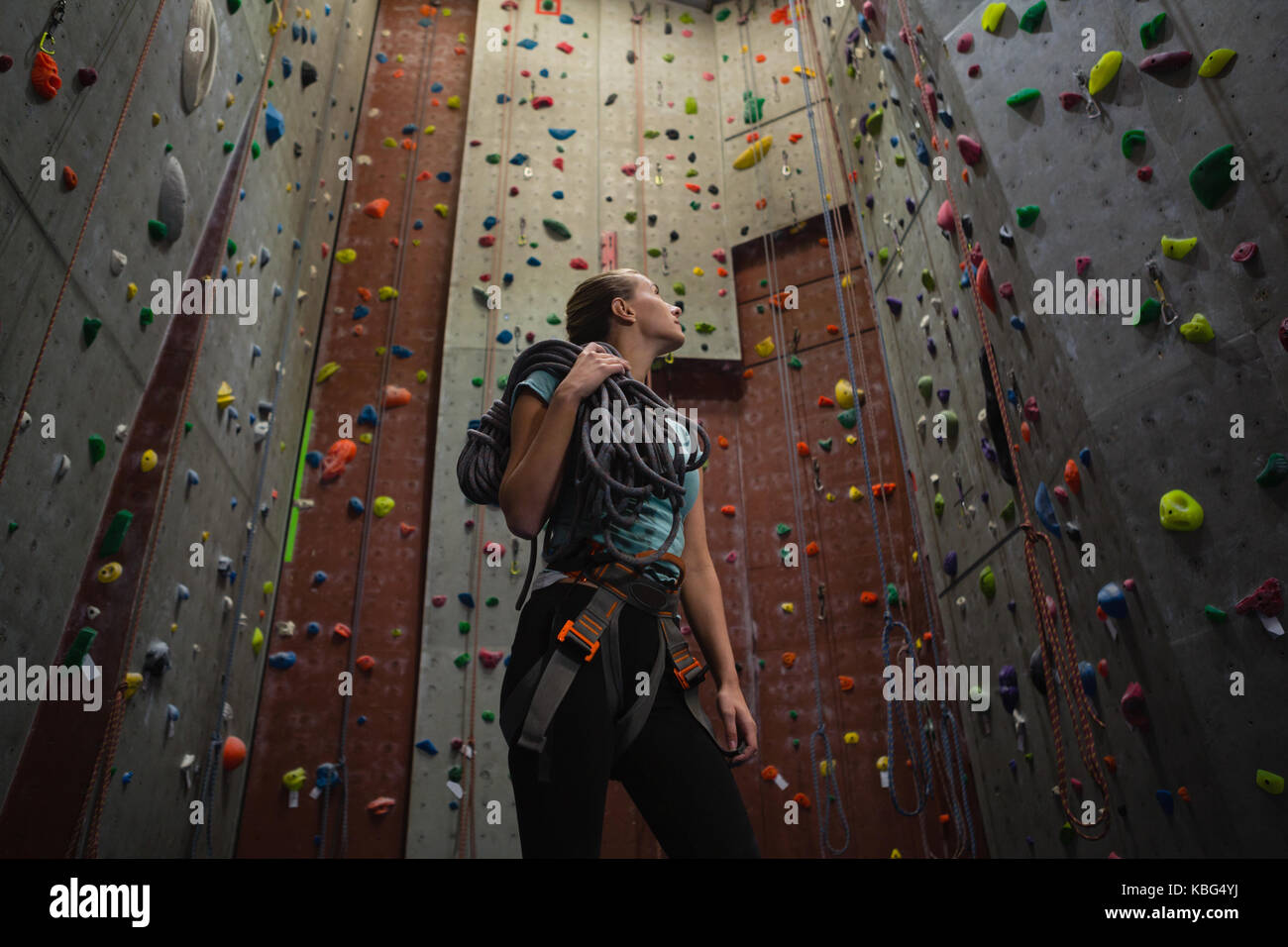 Low angle view of female athlete carrying rope looking up while ...