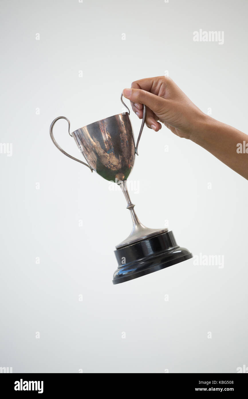 Close-up of hand holding a trophy against white background Stock Photo ...