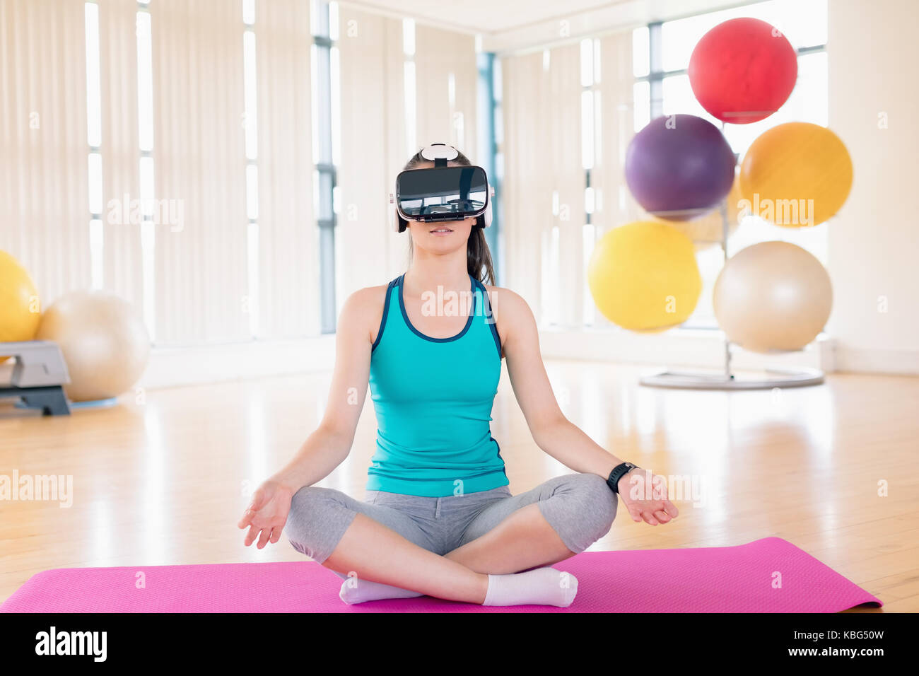 Woman performing yoga while using virtual reality headset in the gym ...