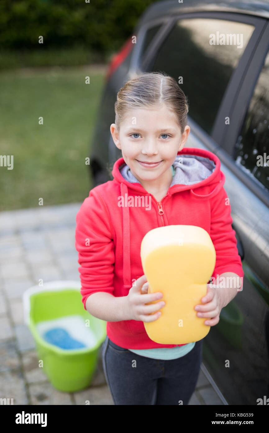 Teenage girl holding a sponge on a sunny day Stock Photo - Alamy