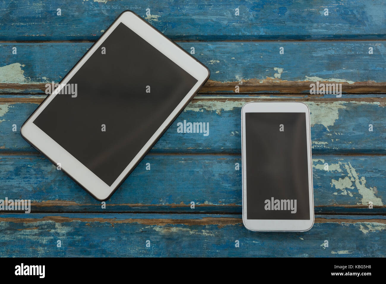 Overhead of mobile phone and digital tablet on wooden plank Stock Photo ...