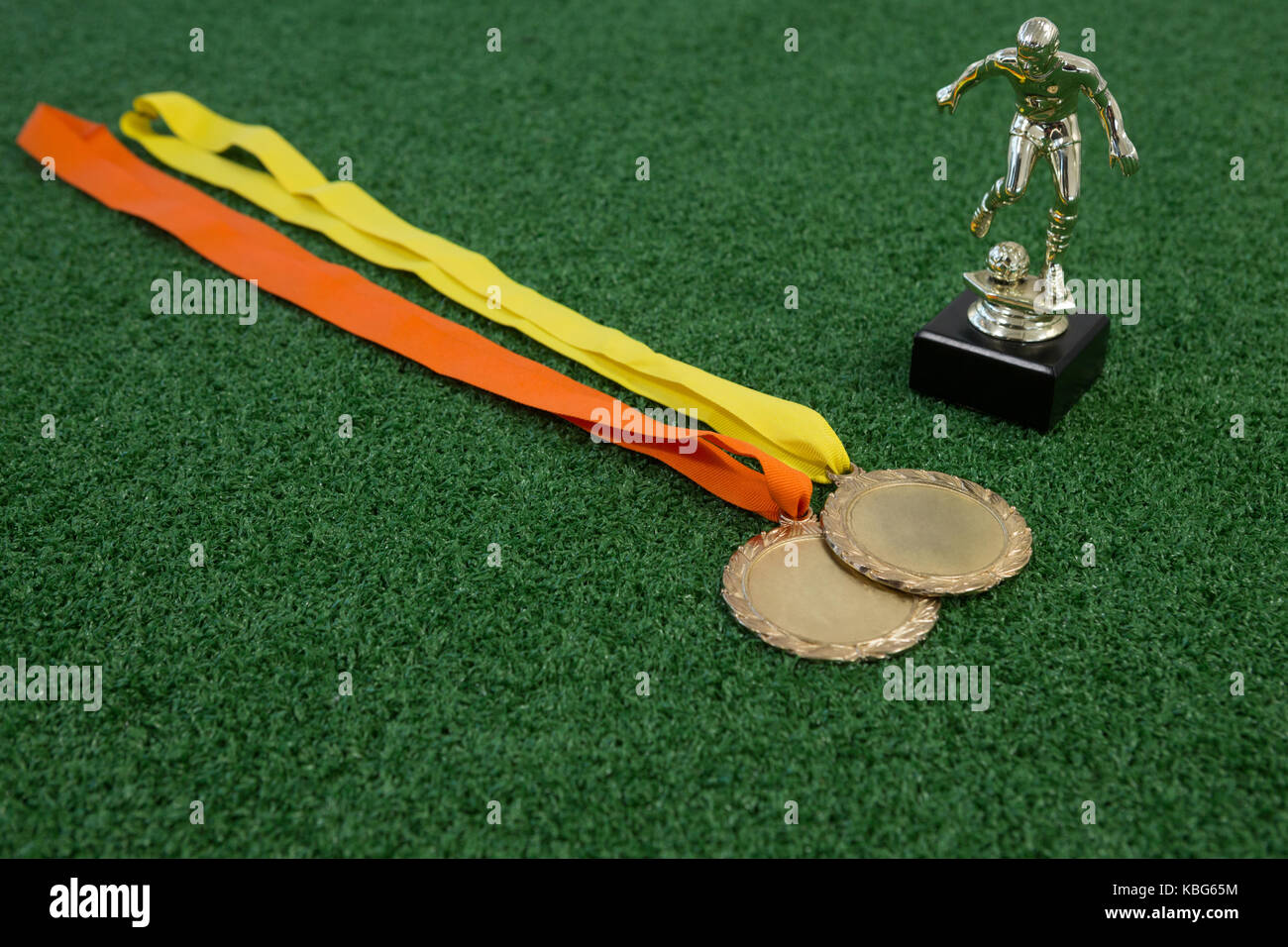 Close-up of trophy and medals on artificial grass Stock Photo - Alamy