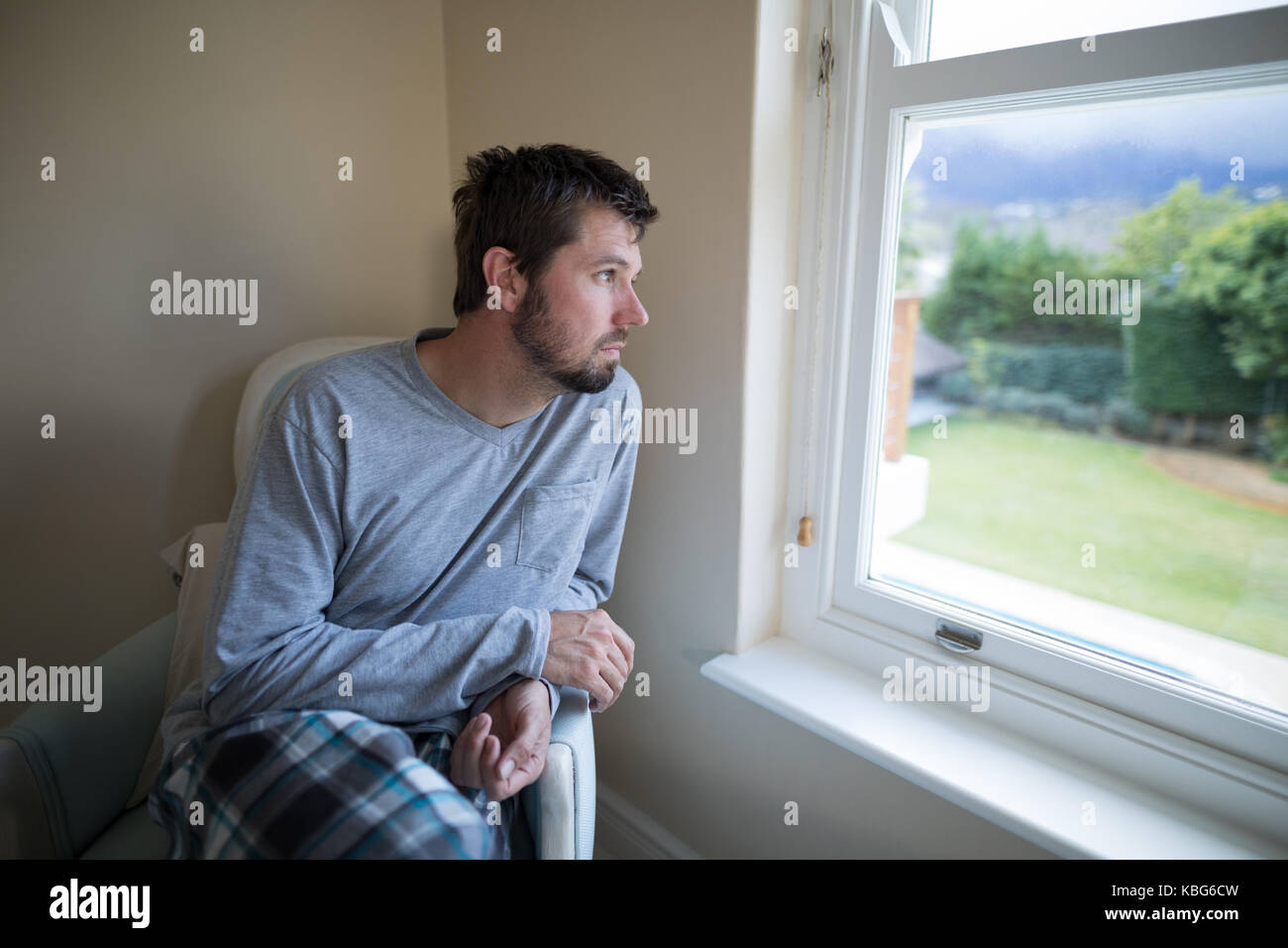 Man looking through the window at home Stock Photo - Alamy
