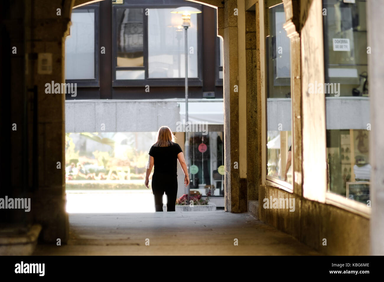 woman walks down the streets pass way. by shop windows in a afternoon ...