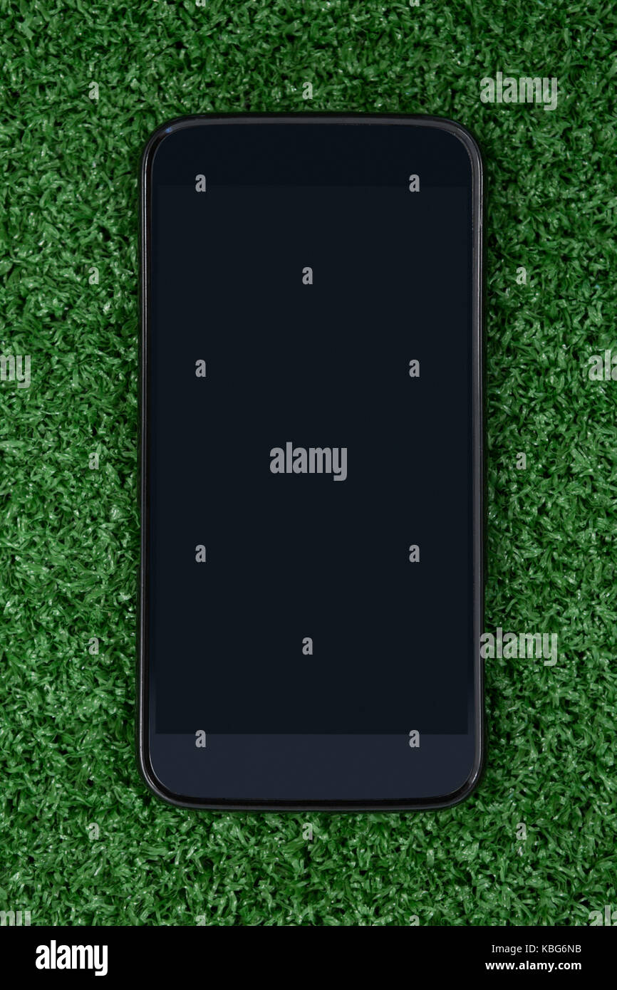 Close-up of mobile phone on artificial grass Stock Photo - Alamy
