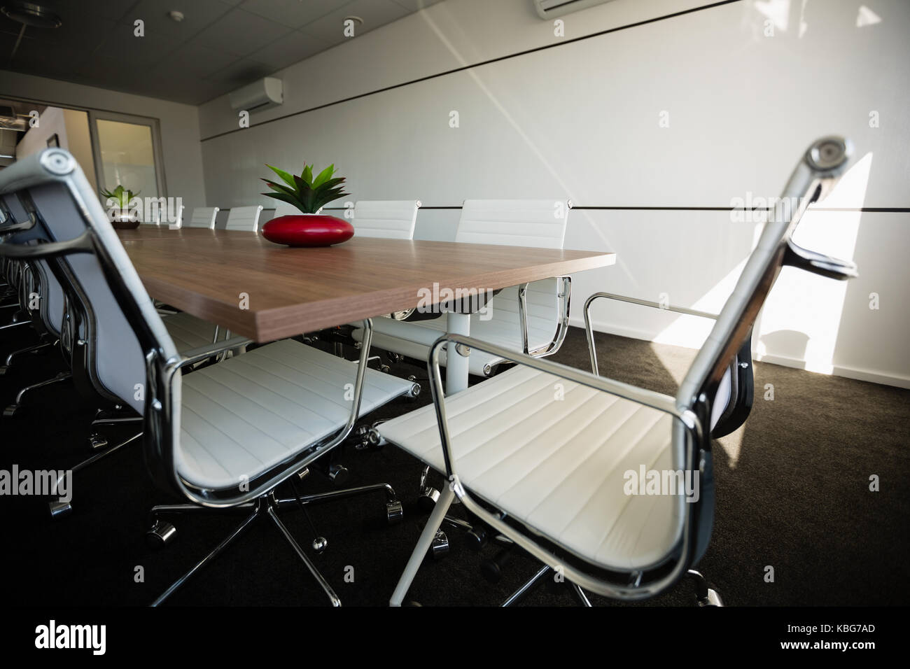 Empty chairs by conference table at modern office Stock Photo - Alamy