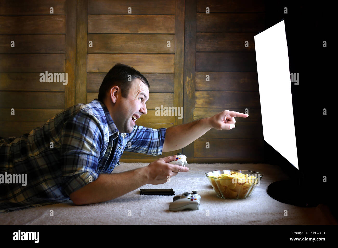 man playing on a console on the joystick before the big TV Stock Photo ...