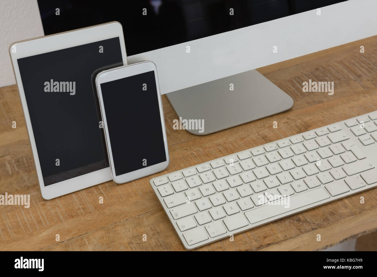 Various electronic gadgets on table in office Stock Photo - Alamy
