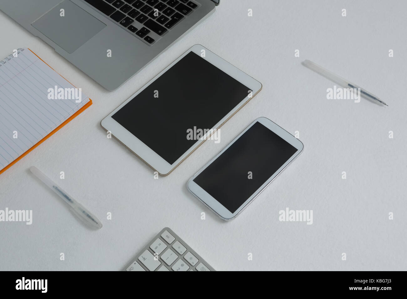 Overhead of various electronic gadgets and book on white background ...