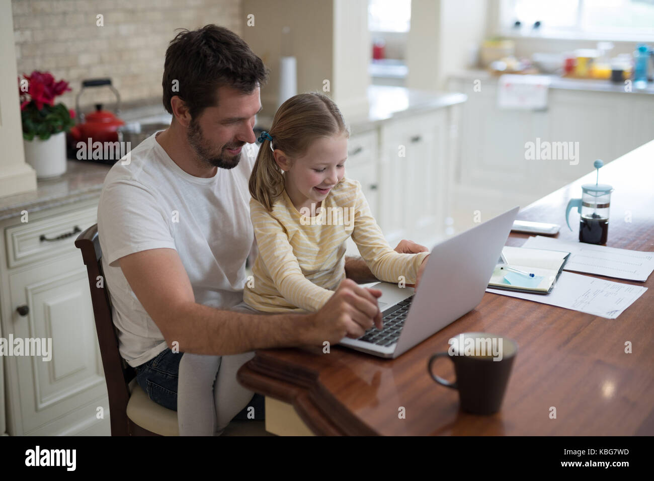 Father and daughter working on laptop at home Stock Photo - Alamy
