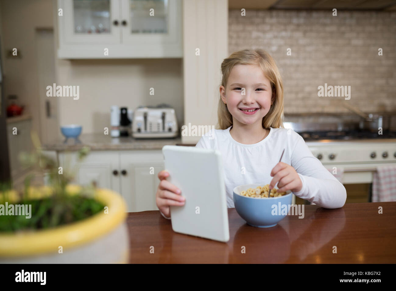Portrait of young girl having breakfast in the kitchen at home Stock ...