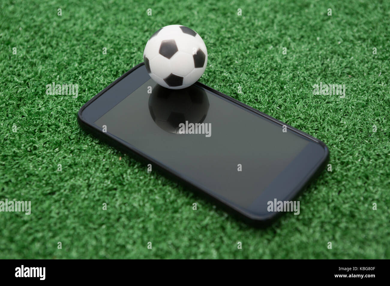 Close-up of football and mobile phone on artificial grass Stock Photo ...
