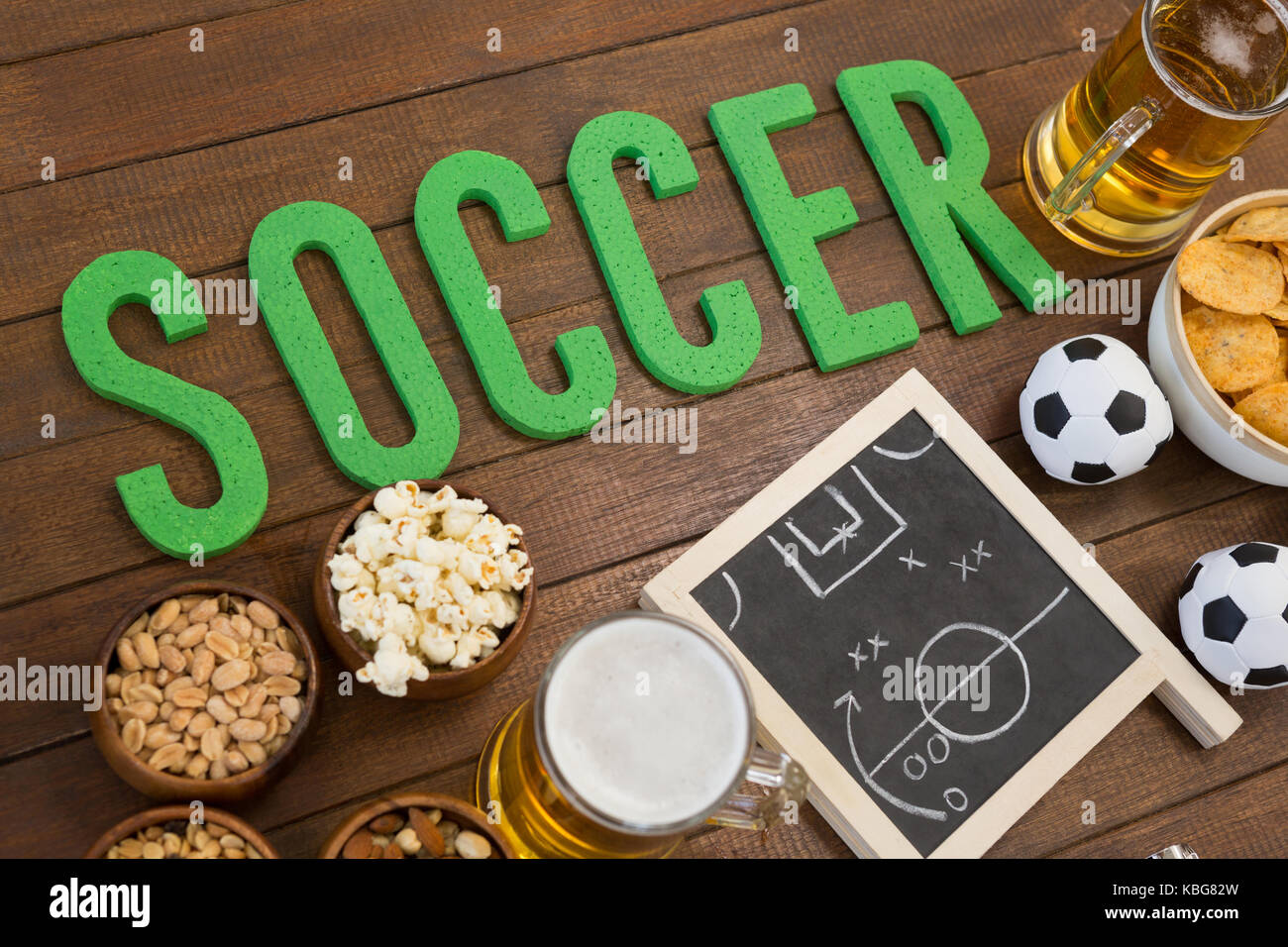 Overhead of strategy board, snacks and football on wooden table Stock ...