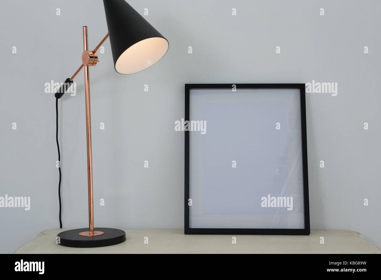 Picture frame and illuminated lamp on wooden table Stock Photo - Alamy