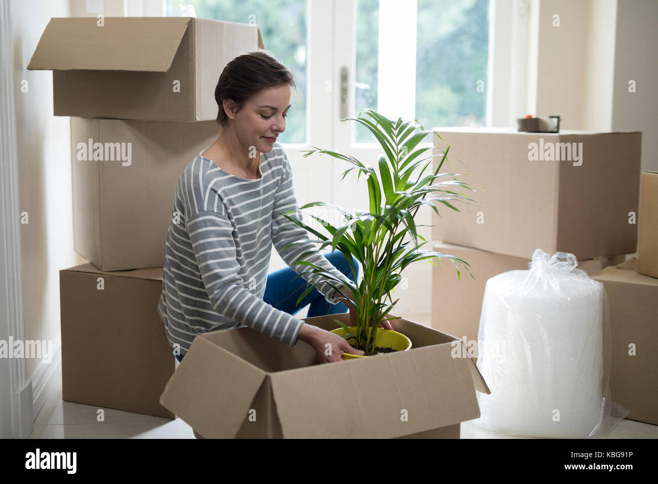 Woman opening cardboard boxes in living room at home Stock Photo - Alamy