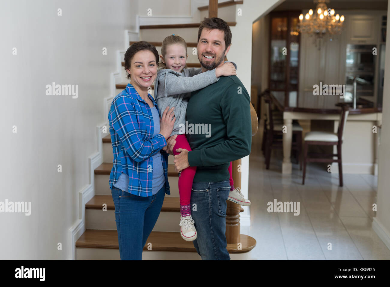 Parents and daughter hugging each other at home Stock Photo - Alamy