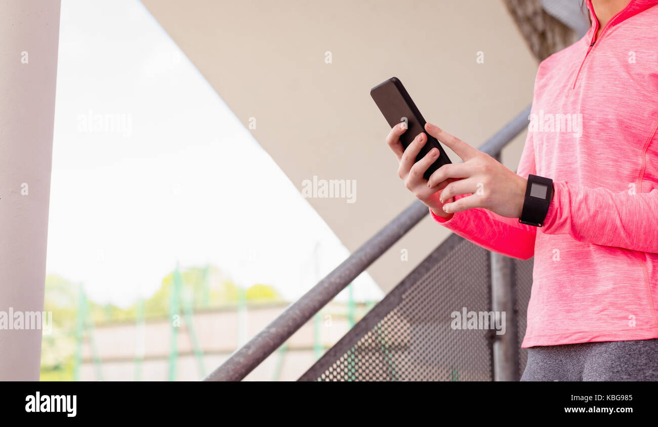 Mid-section of woman using mobile phone in staircase Stock Photo - Alamy