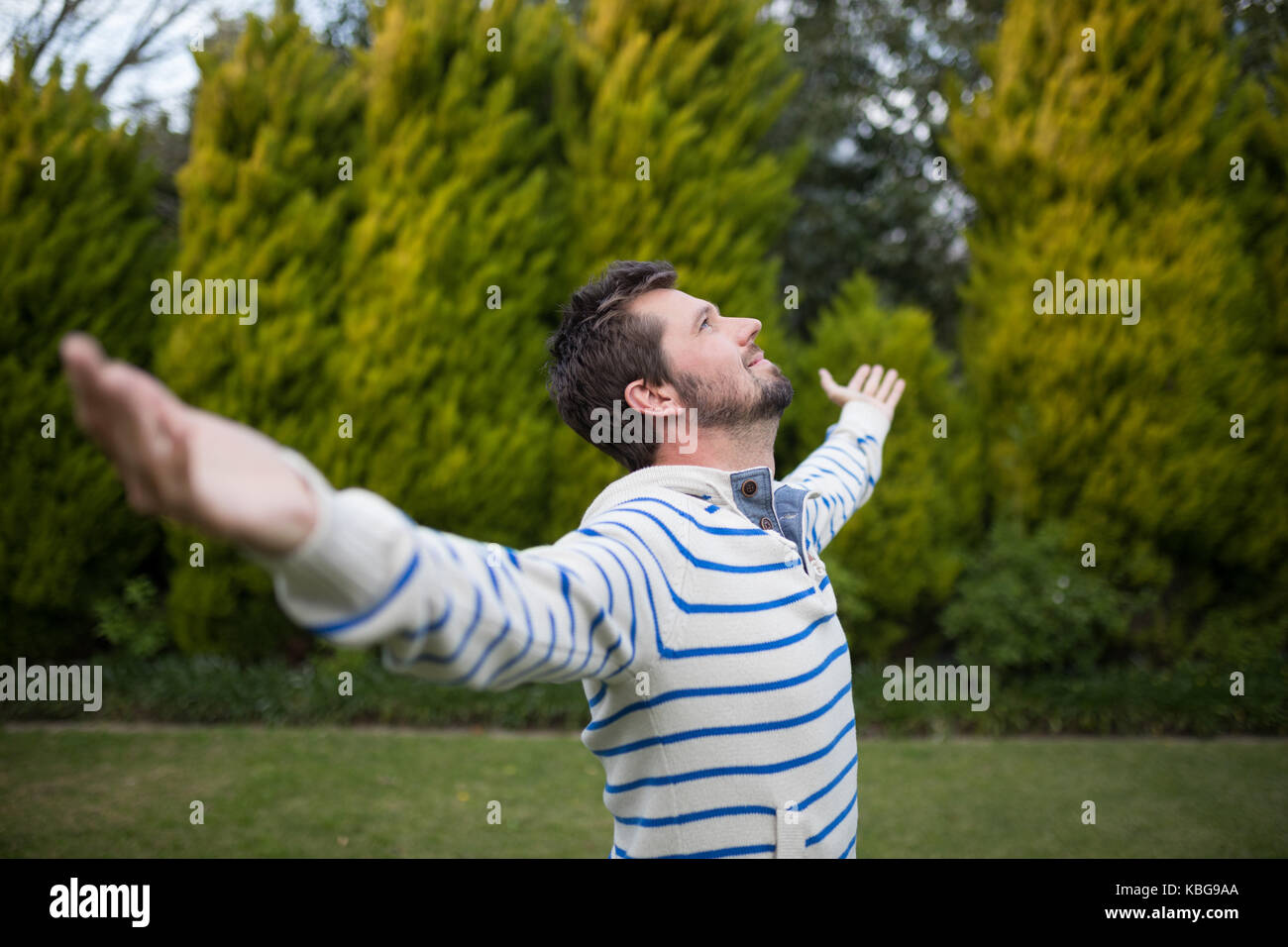 Man standing with arms wide open in the park Stock Photo - Alamy