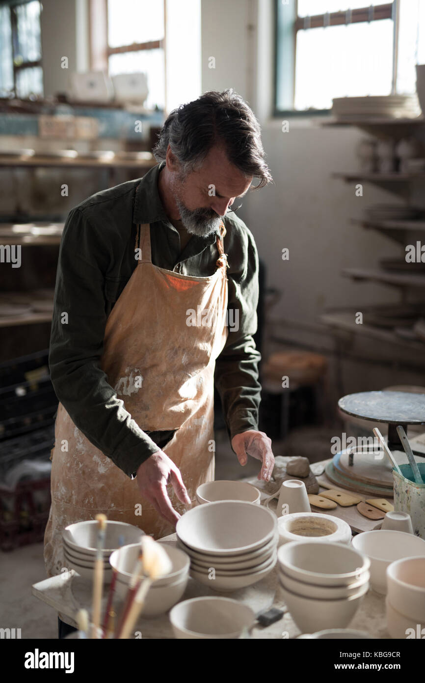Male potter working at worktop in pottery workshop Stock Photo - Alamy