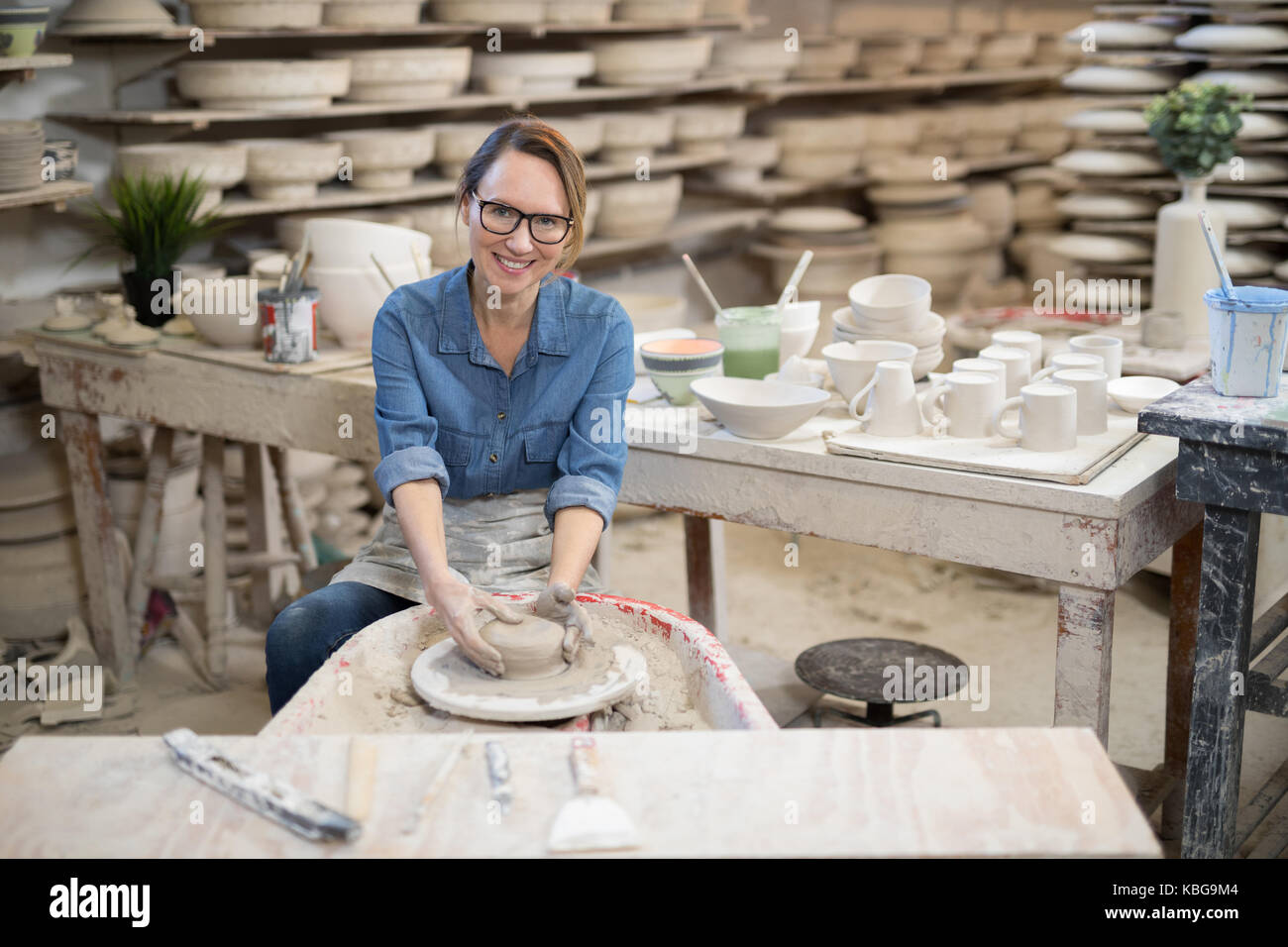 Portrait of female potter molding a clay in pottery workshop Stock ...