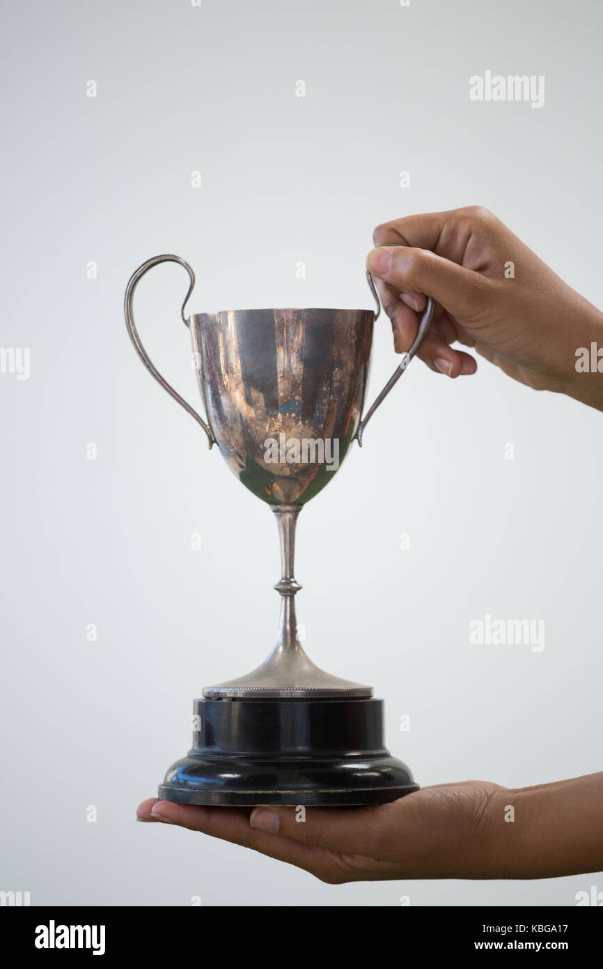 Close-up of hand holding a trophy against white background Stock Photo ...