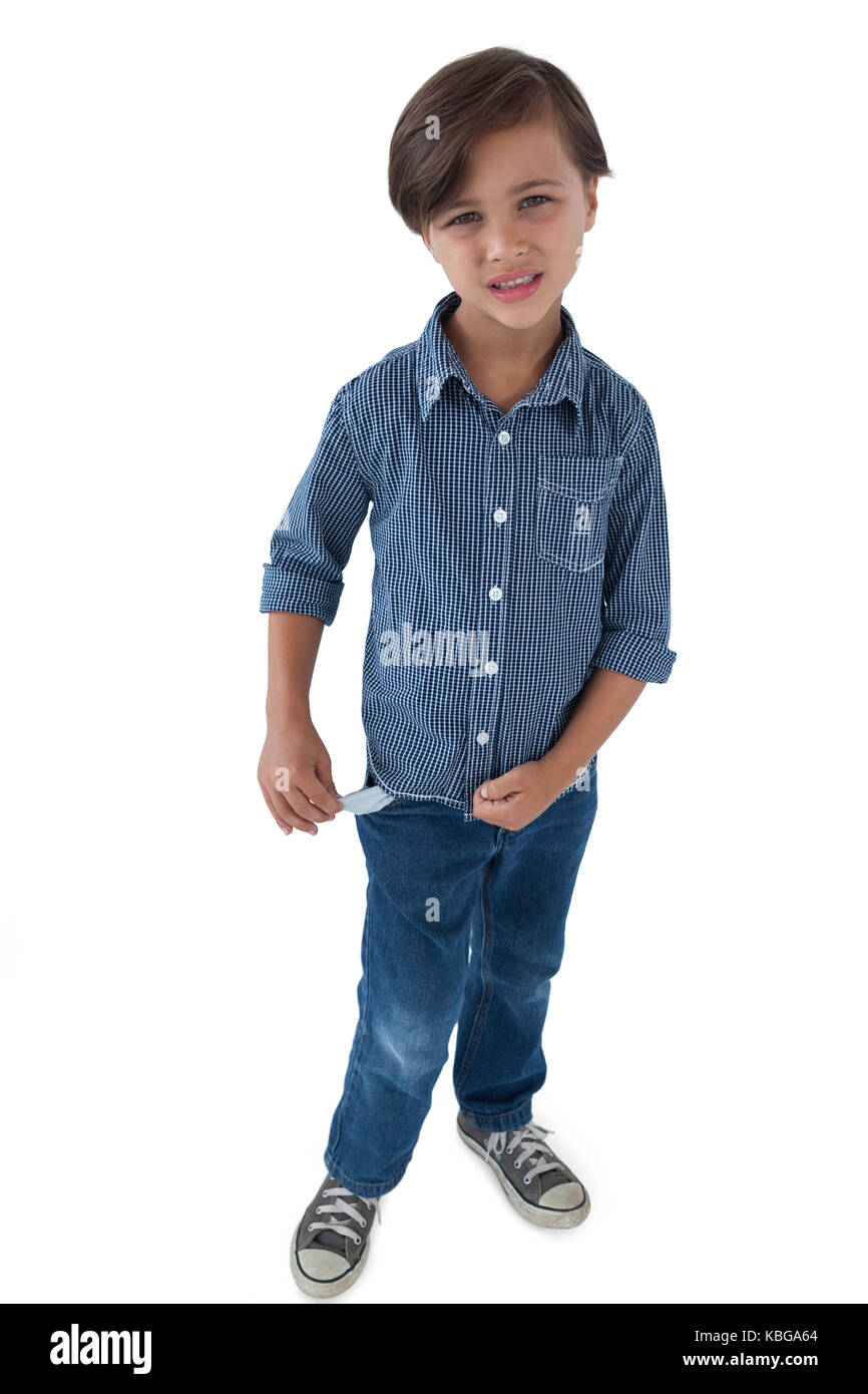 Portrait of boy standing with empty pockets against white background ...