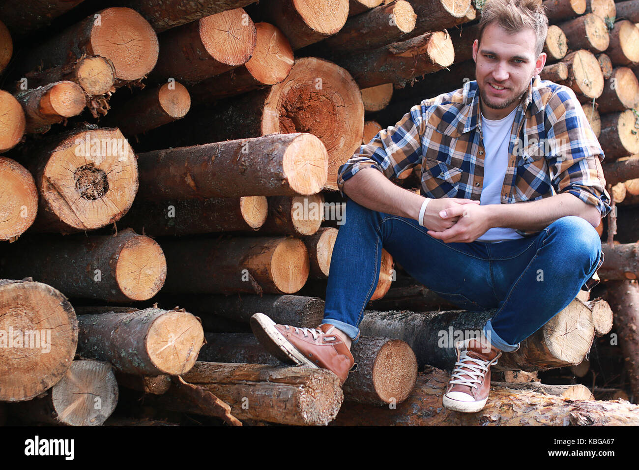 A man at the factory processing wood, sawing logs Stock Photo - Alamy