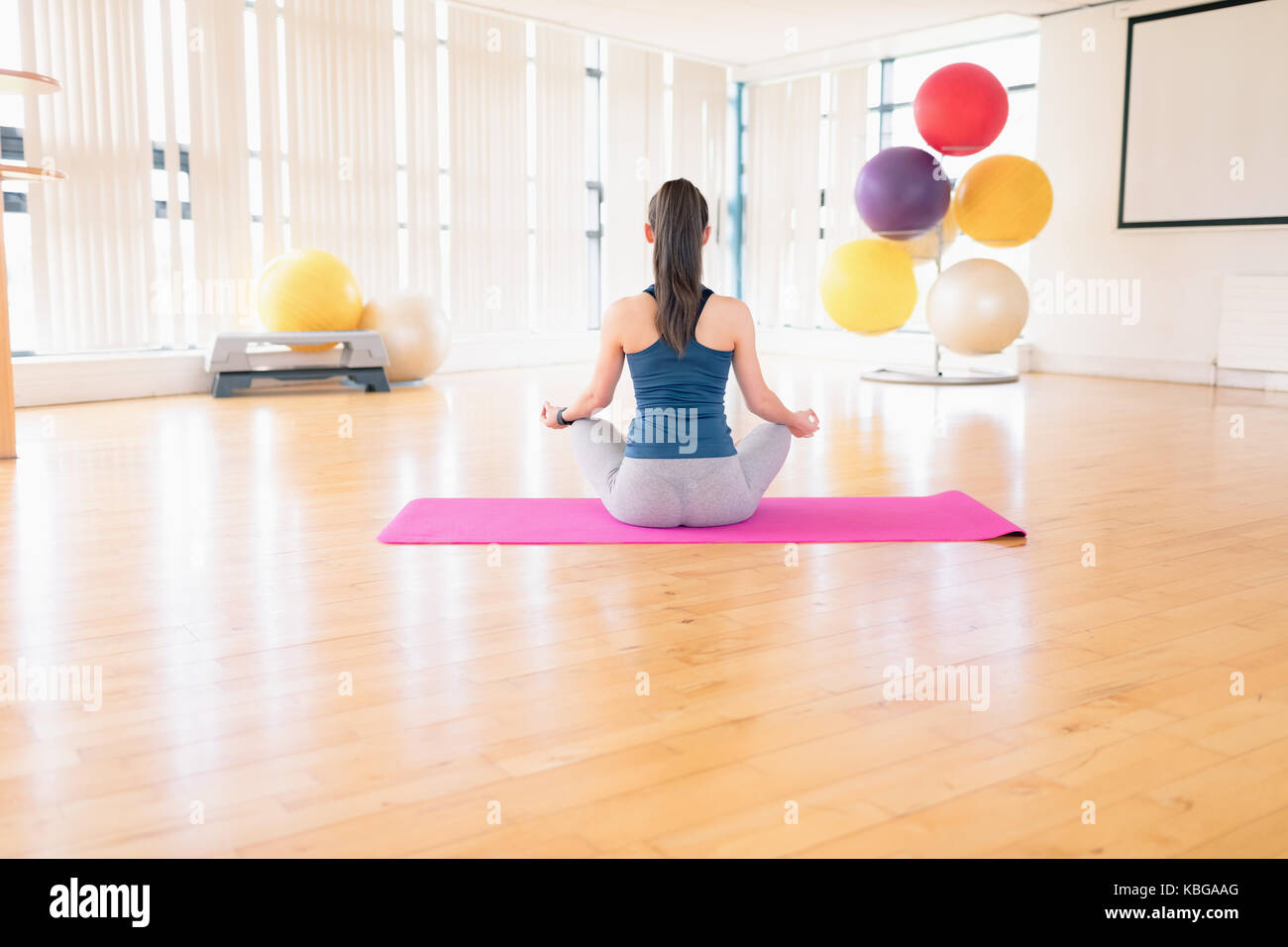 Rear view of woman performing yoga in the gym Stock Photo - Alamy