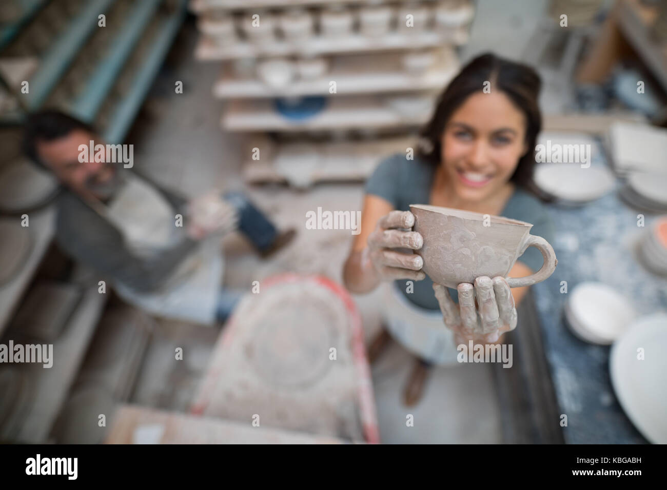 Female potter holding clay cup in pottery workshop Stock Photo - Alamy