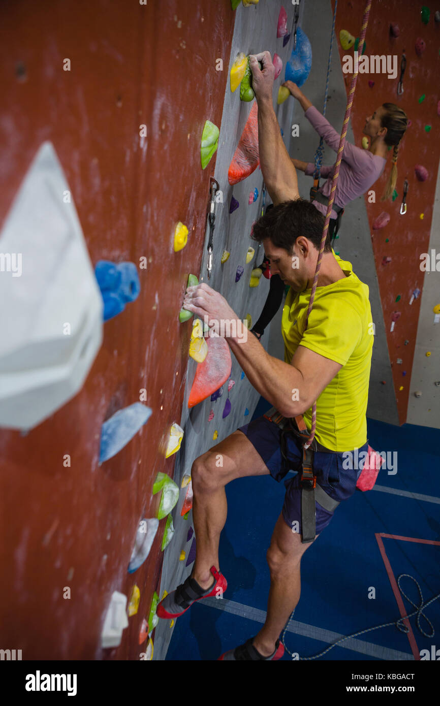 Side view of athletes rock climbing in fitness club Stock Photo - Alamy