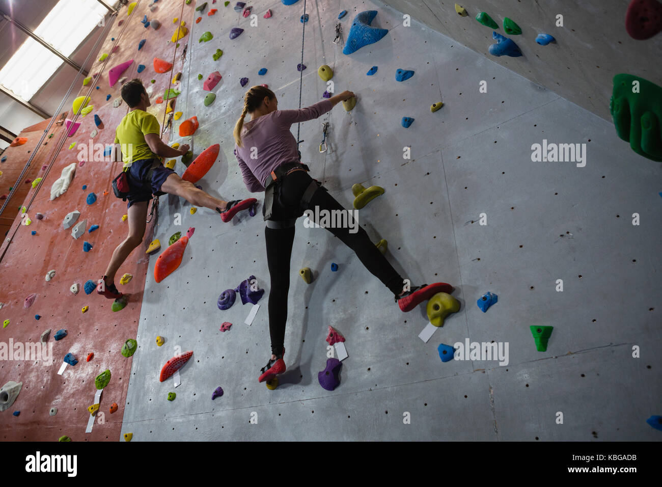 Low angle view of athletes rock climbing in fitness club Stock Photo ...