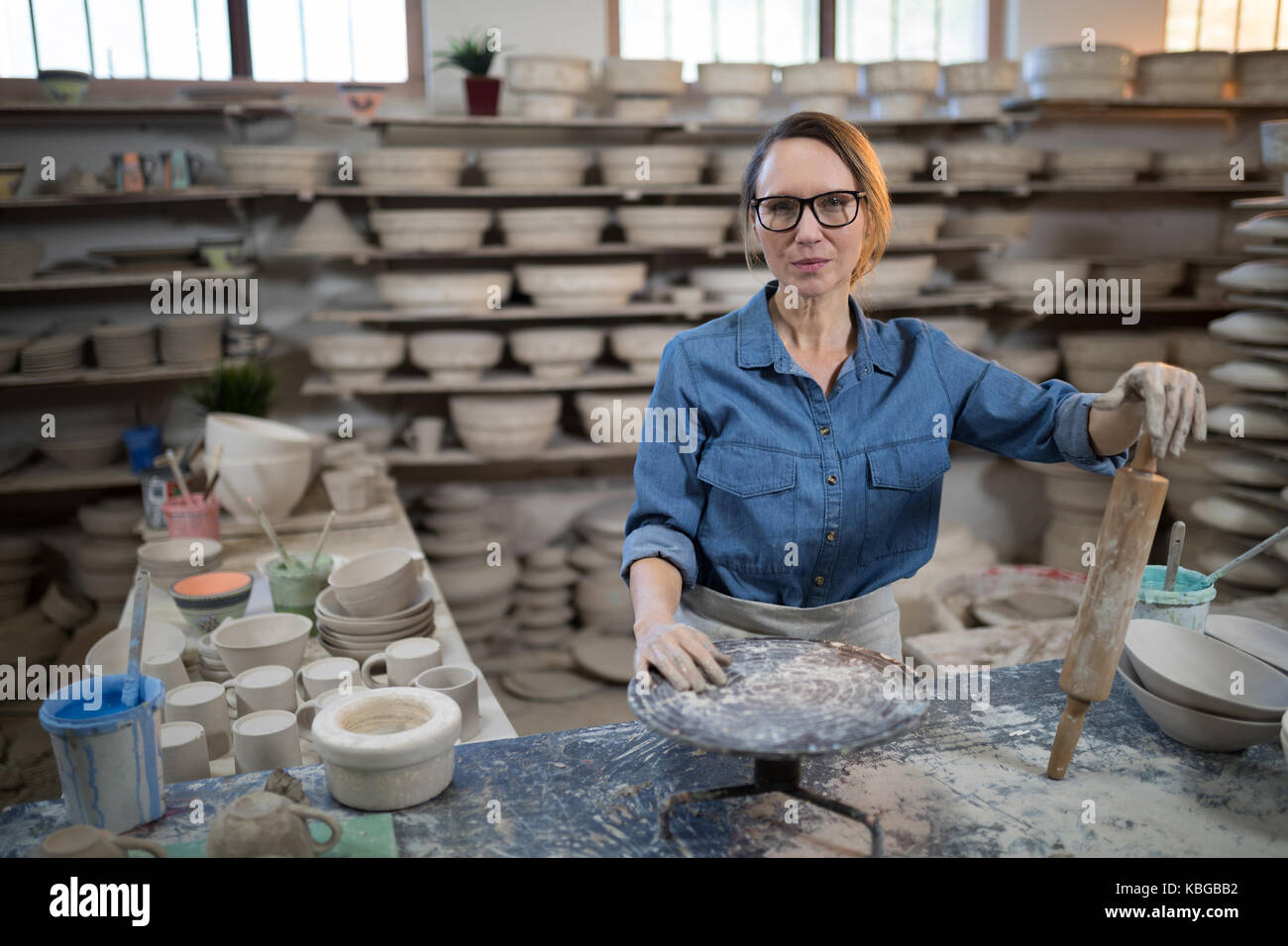 Female potter standing at worktop in pottery workshop Stock Photo - Alamy