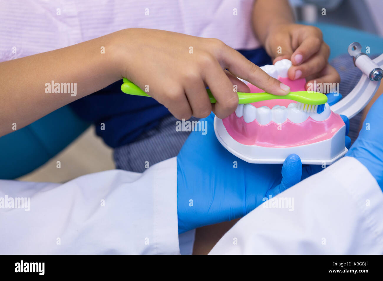 Close-up of dentist and boy brushing dentures at clinic Stock Photo - Alamy