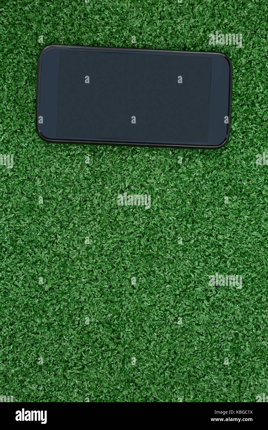 Overhead view of mobile phone on artificial grass Stock Photo - Alamy