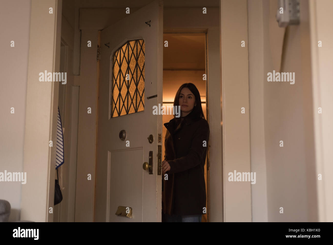 Young woman opening door at home Stock Photo - Alamy