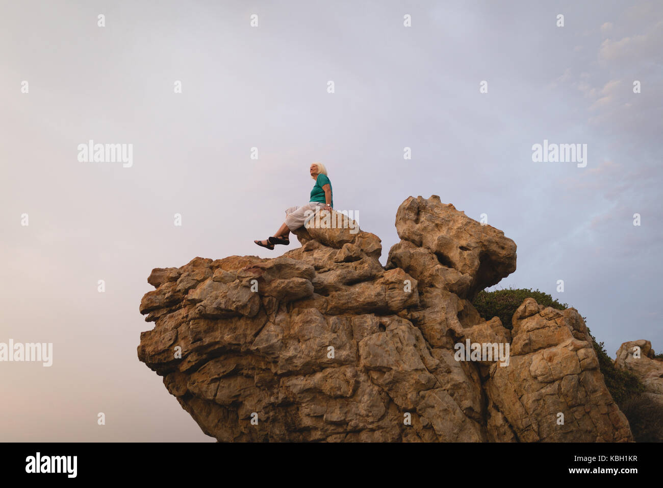 Woman sitting on top cliff hi-res stock photography and images - Alamy