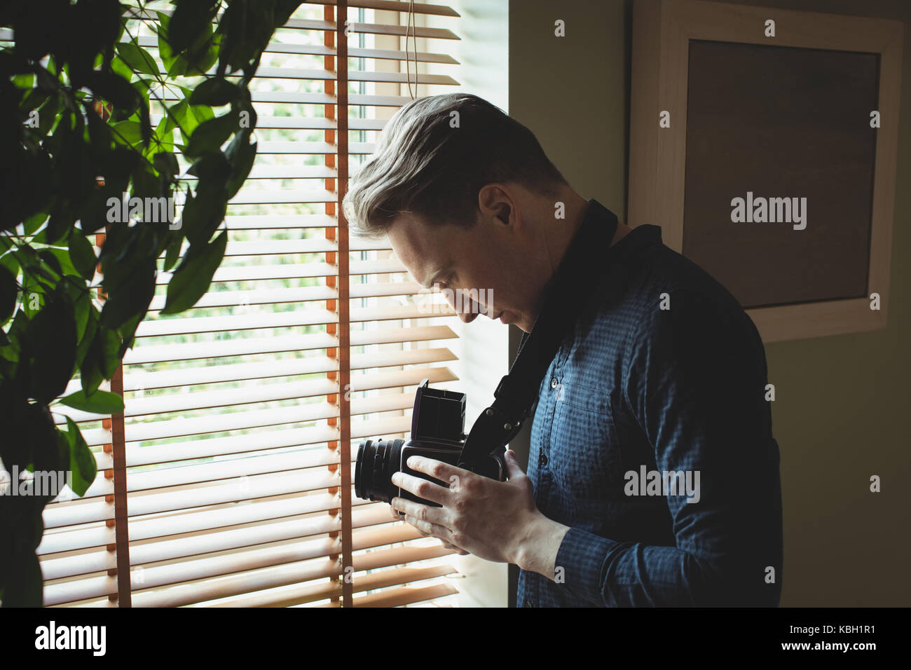 Man holding vintage camera near window at home Stock Photo - Alamy