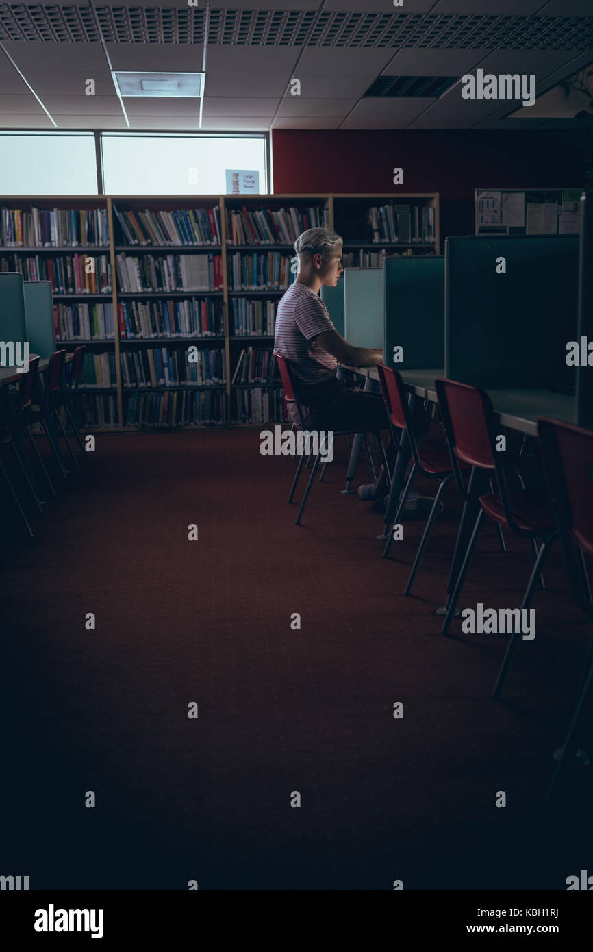 Man studying at desk in library Stock Photo - Alamy